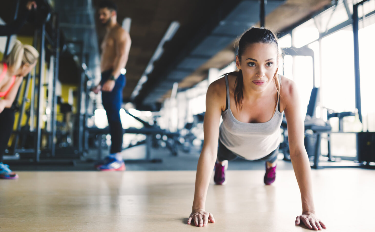 Healthy focused girl doing push ups - Hybrid Fitness